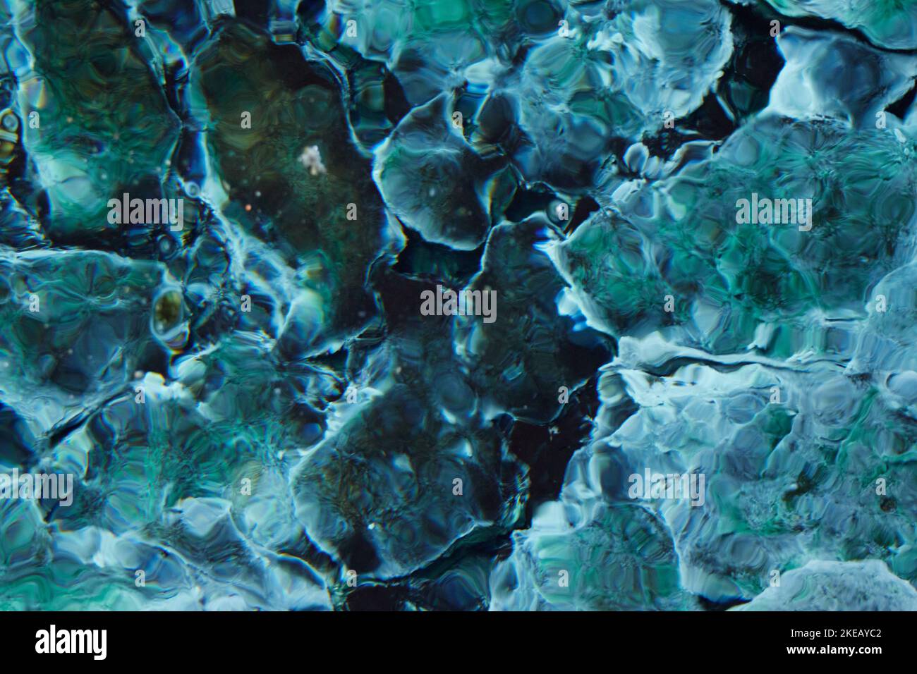 An abstract water texture. Turquoise transparent wavy surface of a pond ...