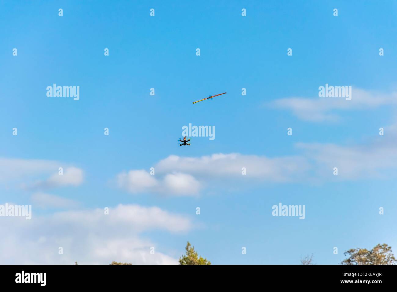 A quadcopter drone and a remote-controlled aircraft drone UAV flying ...