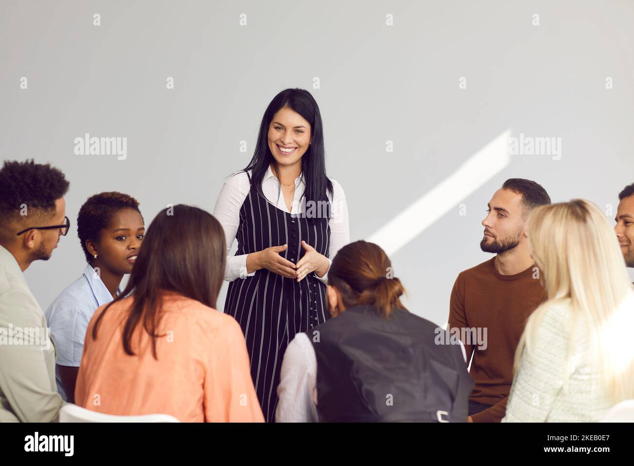 Smiley business speaker, coach or psychologist meeting with diverse ...