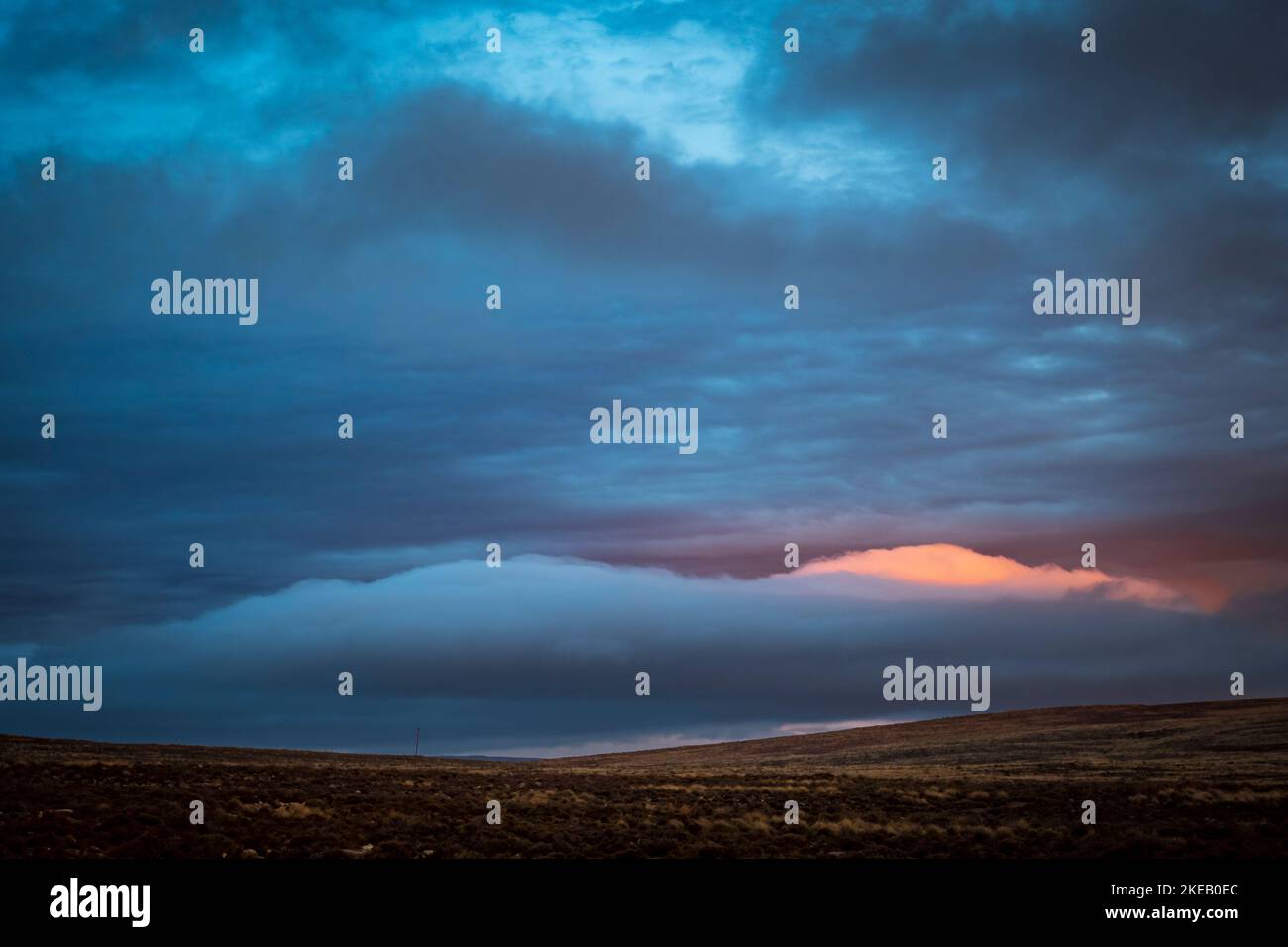 The last rays of the afternoon sun lighting up clouds in a cold, moody ...