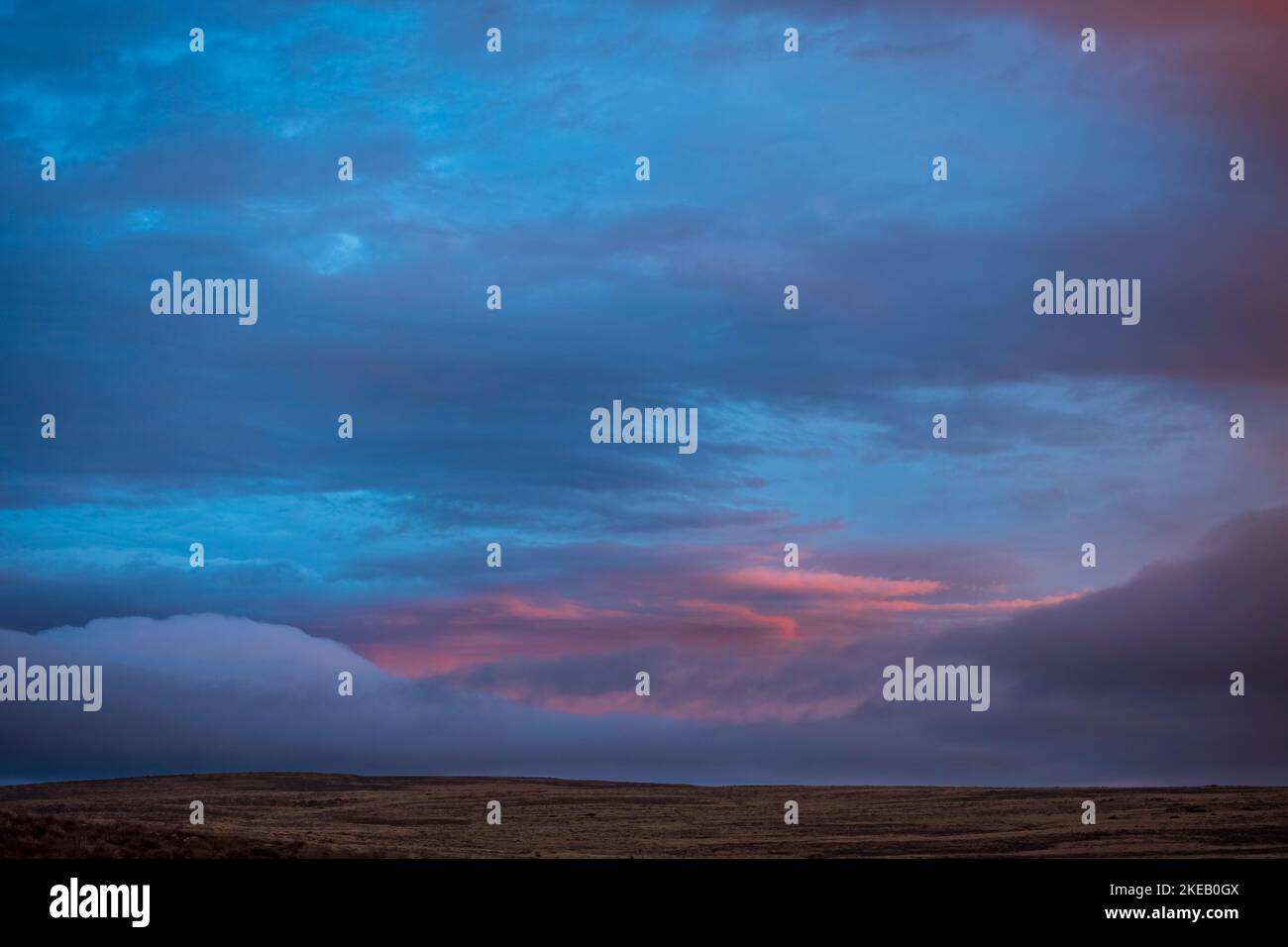 The last rays of the afternoon sun lighting up clouds in a cold, moody ...