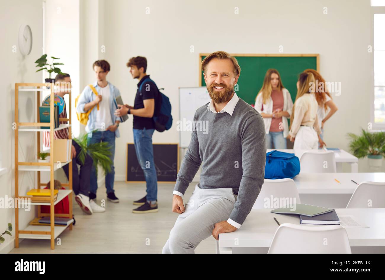 Portrait of a cheerful man who works as a school teacher standing in ...