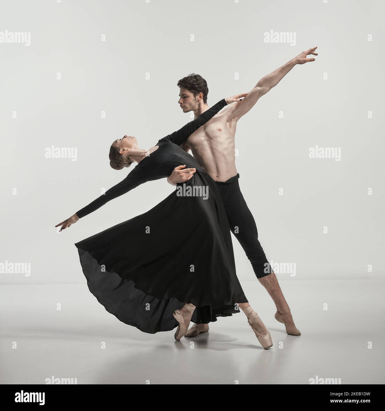 Young muscular man and woman in black silk dress, ballet dancers ...