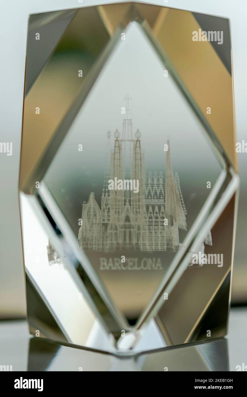 Sagrada Familia trinket in glass material reflected on a white table ...