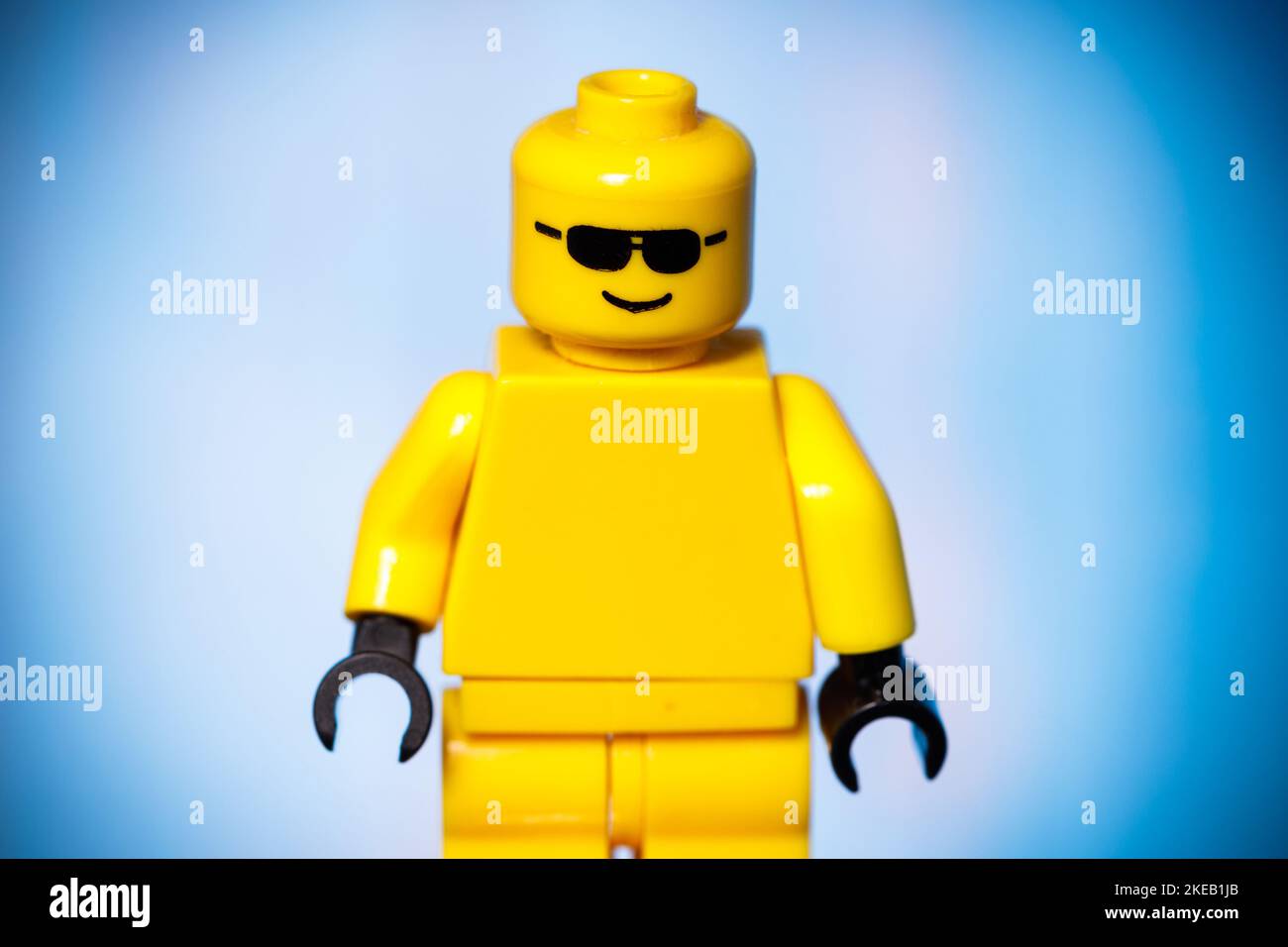 yellow lego figurine with joy on his face on a blue background with a ...