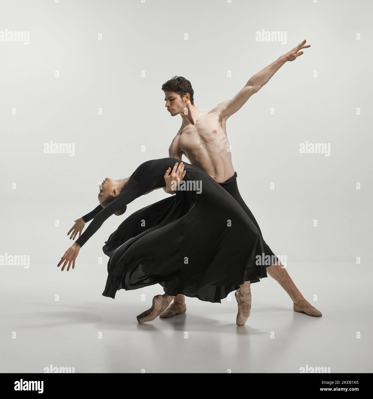 Young man and woman, ballet dancers performing on stage isolated over ...