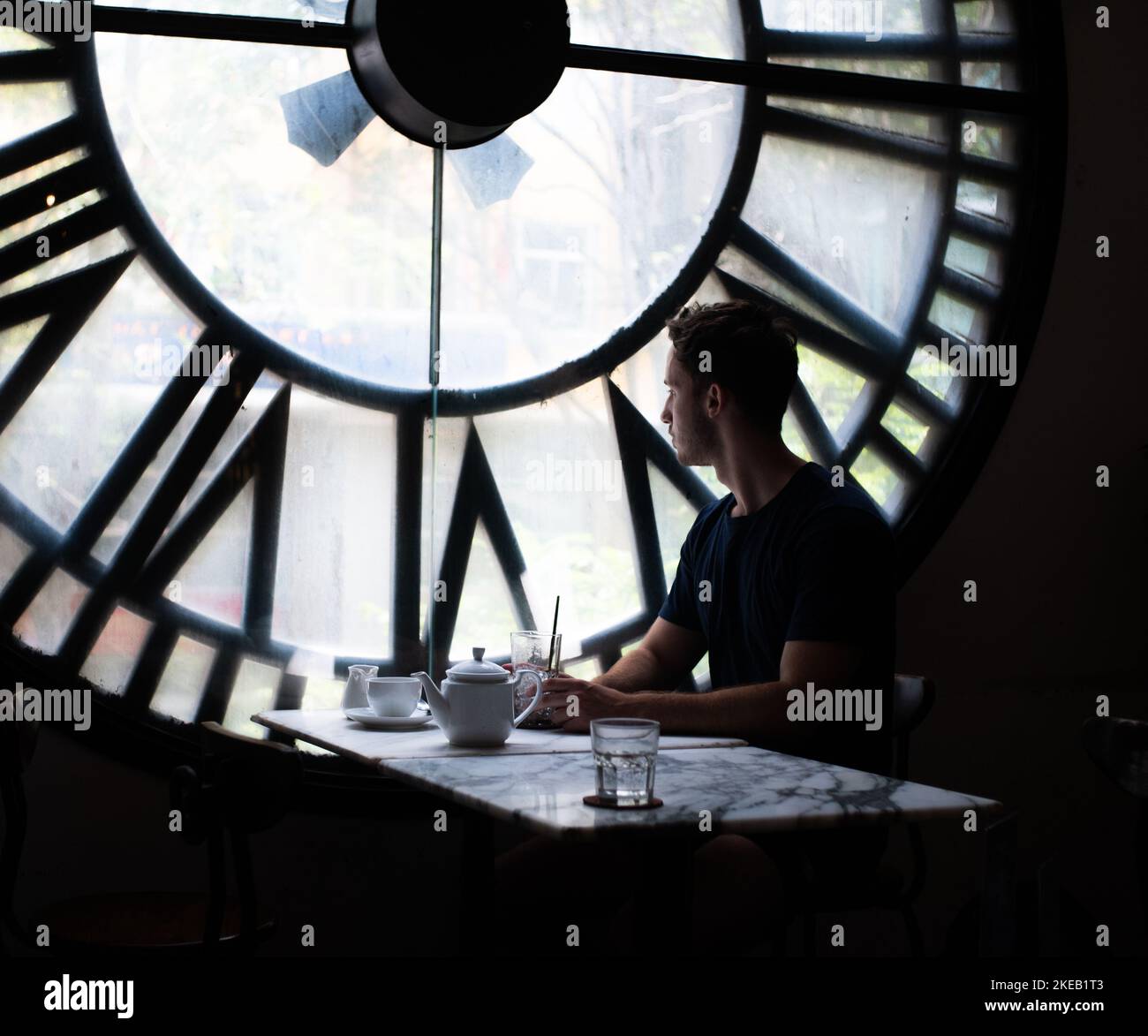 A young Australian man sitting on the table, drinking juice and looking ...