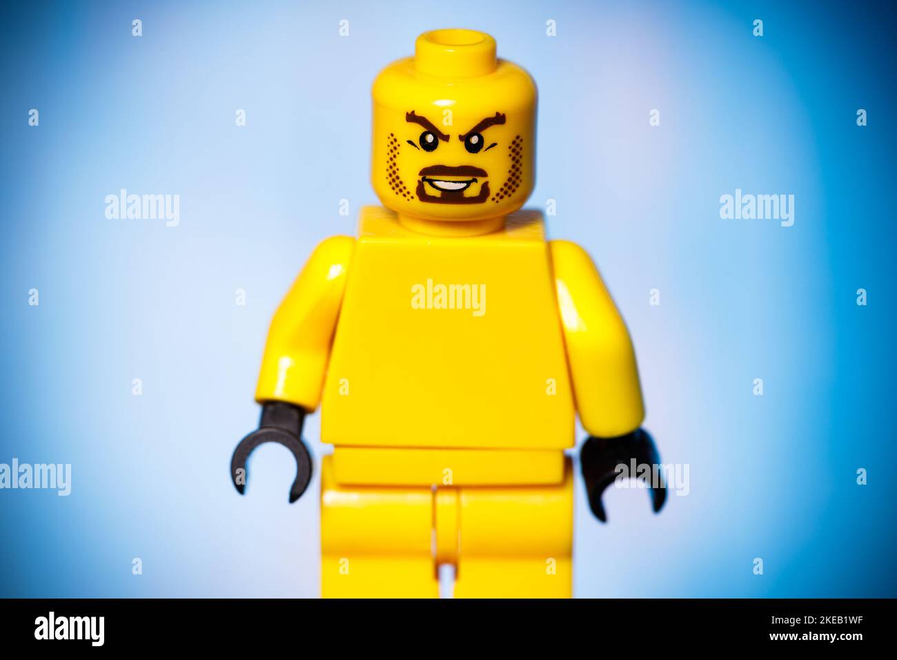 yellow lego figure with an angry face on a blue background. High ...