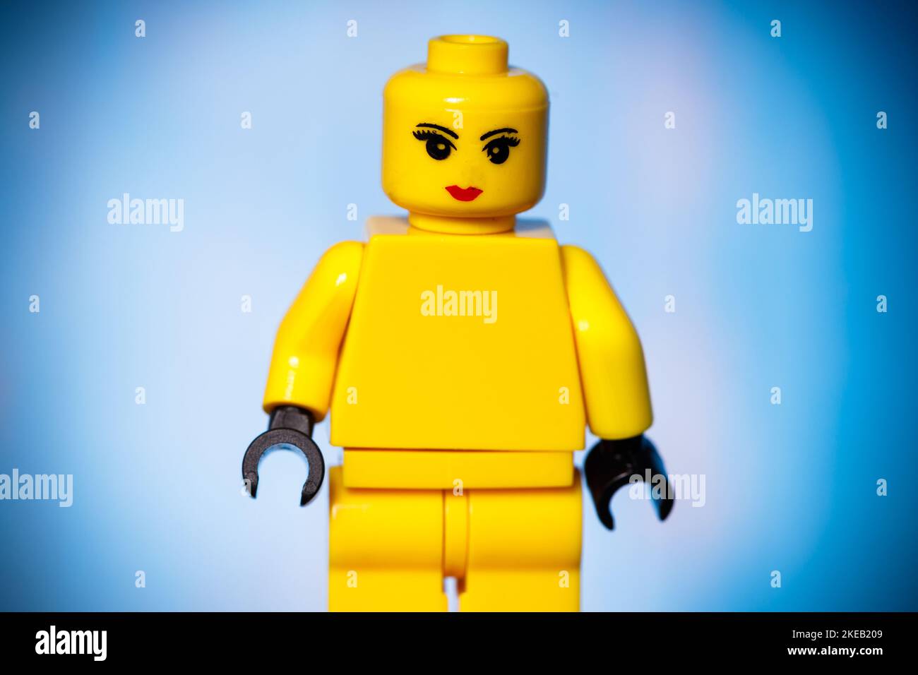 yellow lego figurine with joy on his face on a blue background with a ...