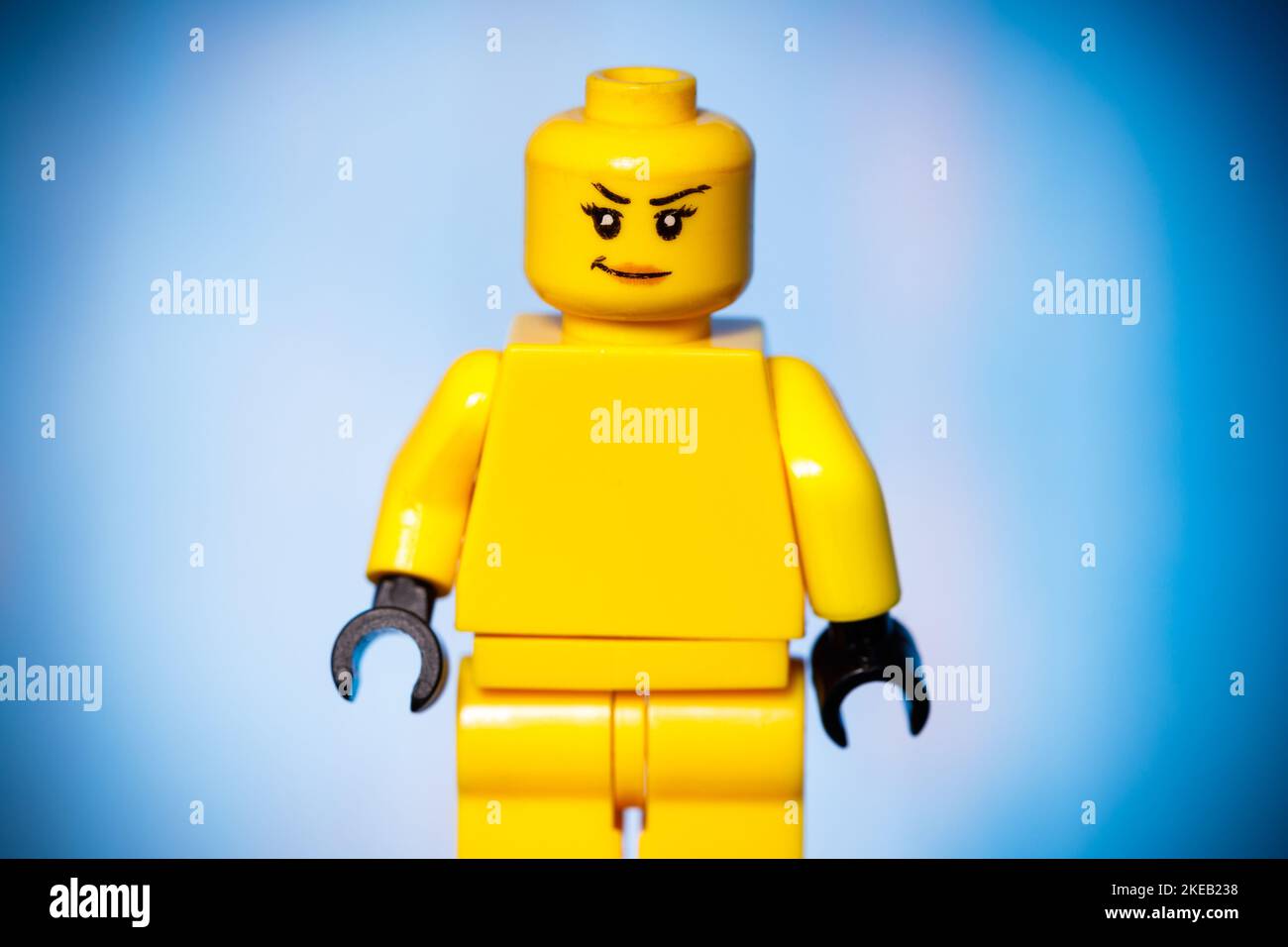 yellow lego figurine with joy on his face on a blue background with a ...