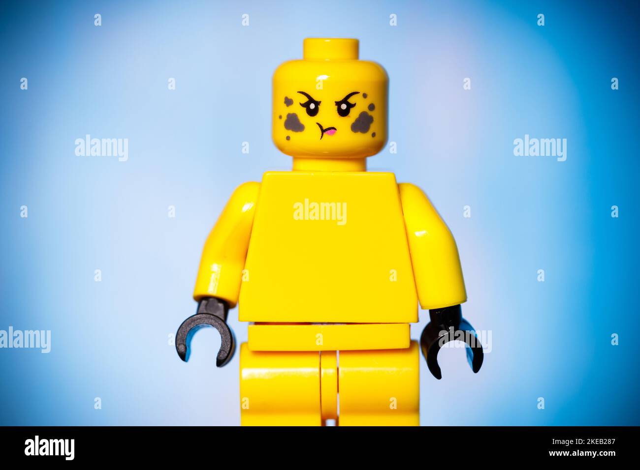 yellow lego figure with an evil face on a blue background with a ...