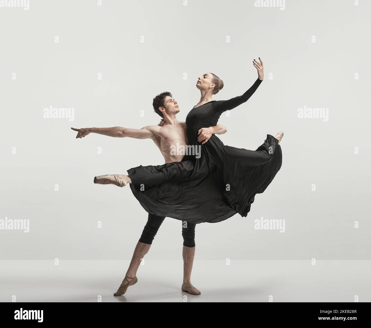 Young muscular man and woman in black silk dress, ballet dancers ...