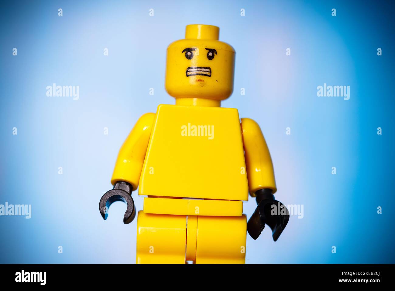 yellow lego figure with an evil face on a blue background with a ...