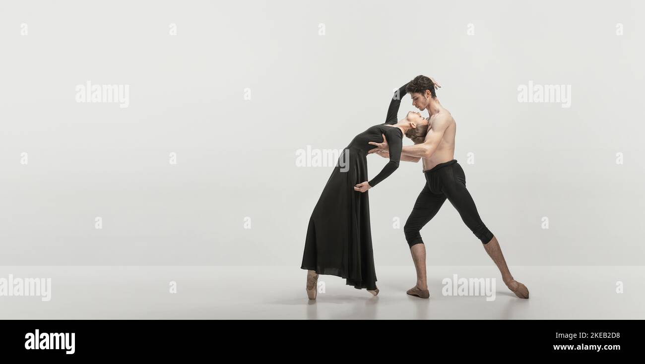 Young man and woman, ballet dancers performing isolated over grey ...