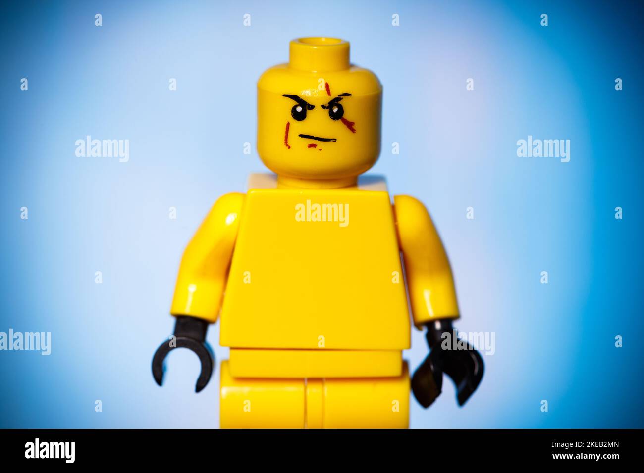 yellow lego figure with a sarcastic face on a blue background. High ...