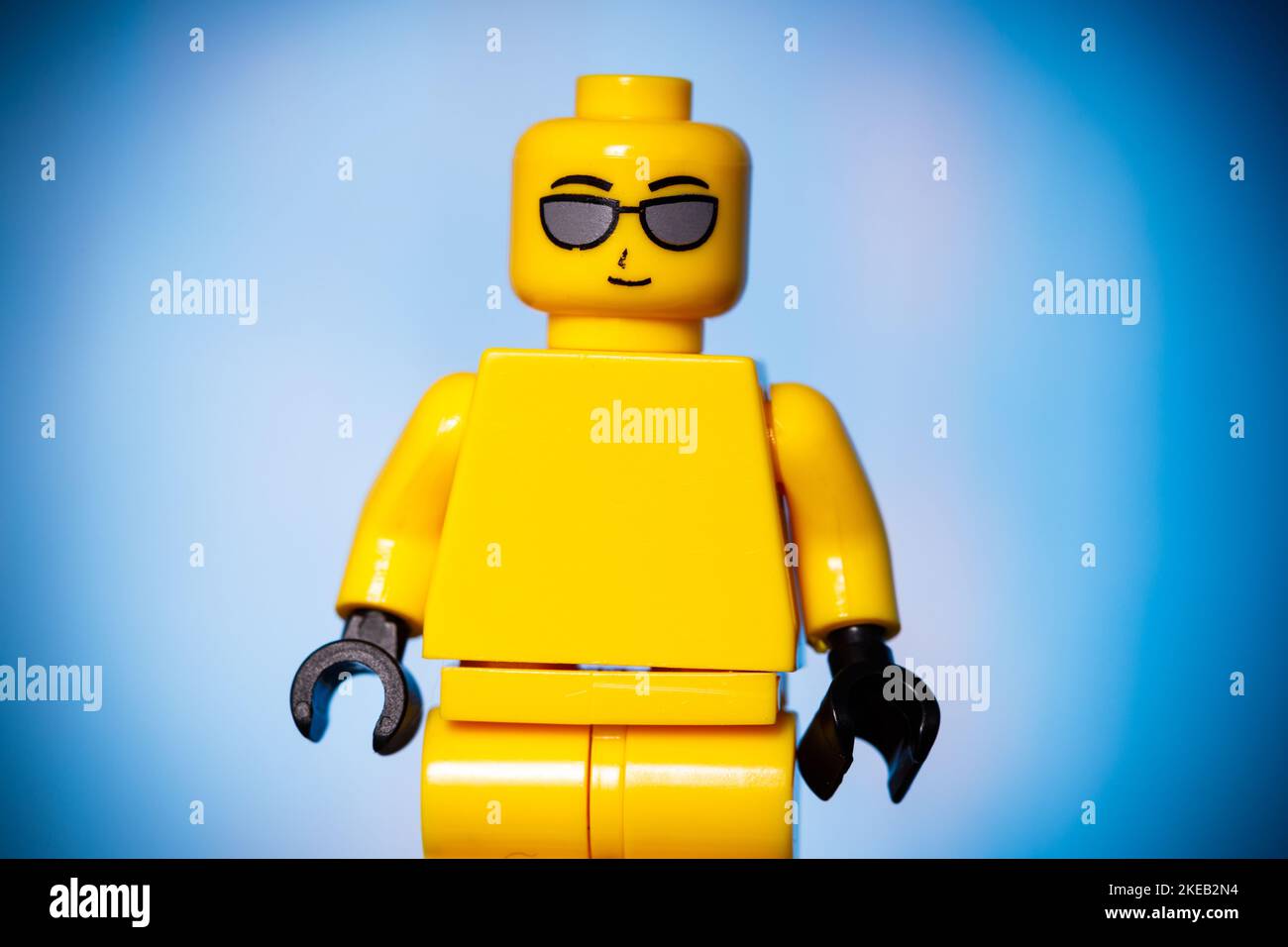 yellow lego figurine with joy on his face on a blue background with a ...