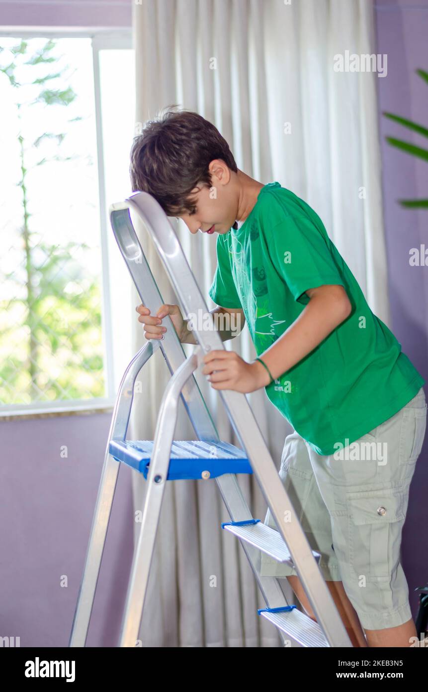 Portrait of a child climbing a stainless steel ladder. Skill at home ...