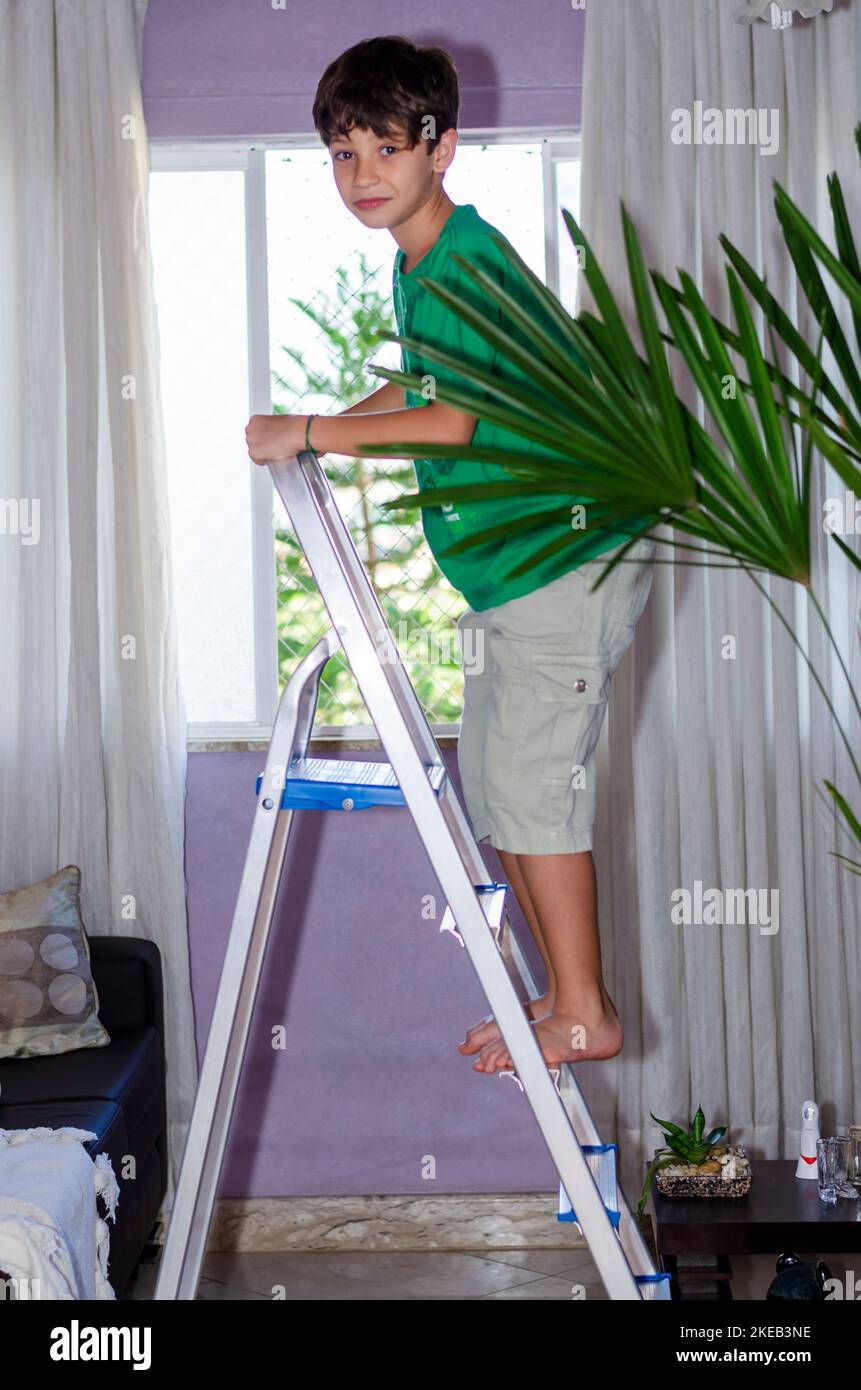 Portrait of a child climbing a stainless steel ladder. Skill at home ...