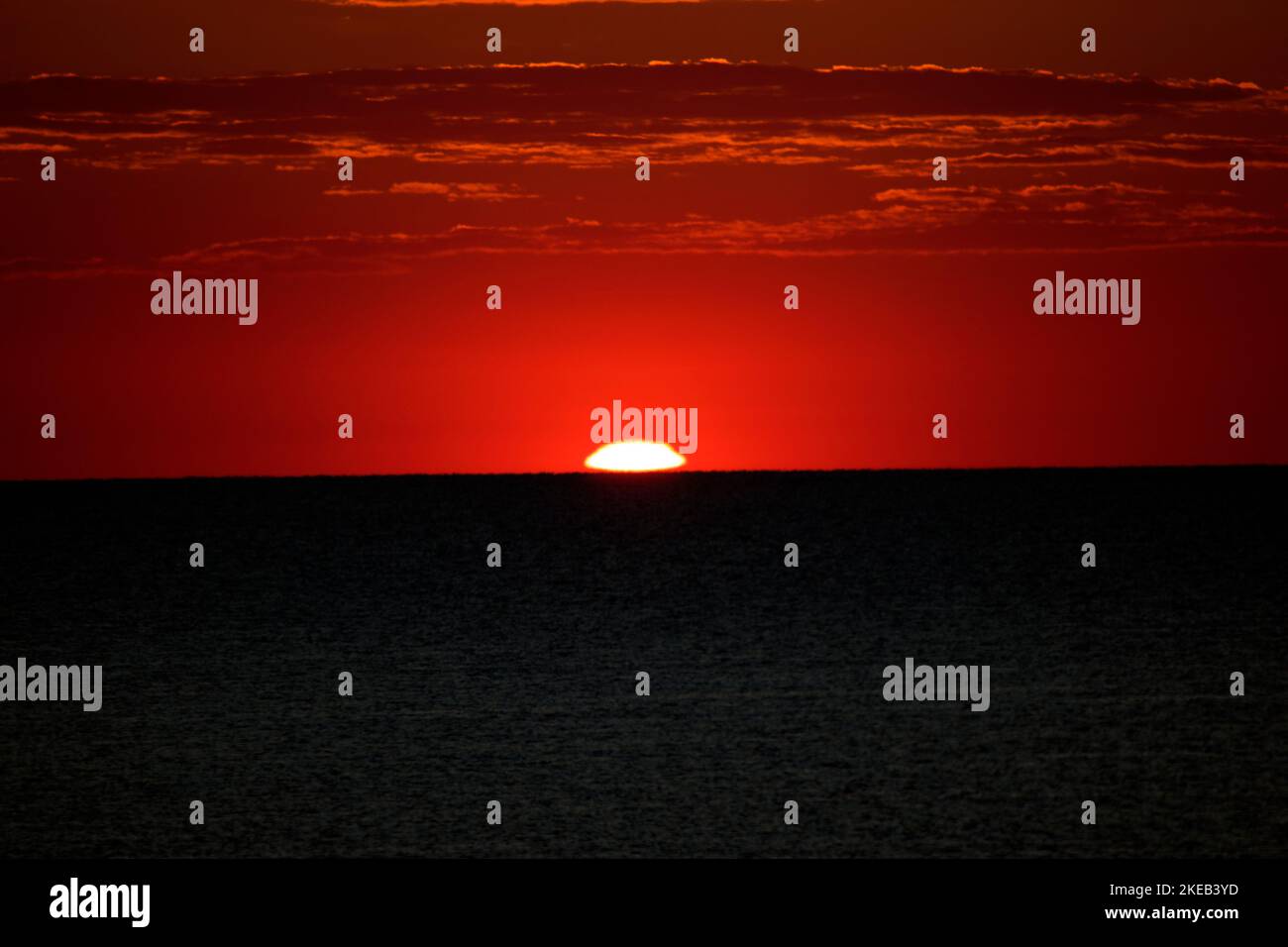 A spectacular sunrise over the sea, the sun rising from beyond the ...