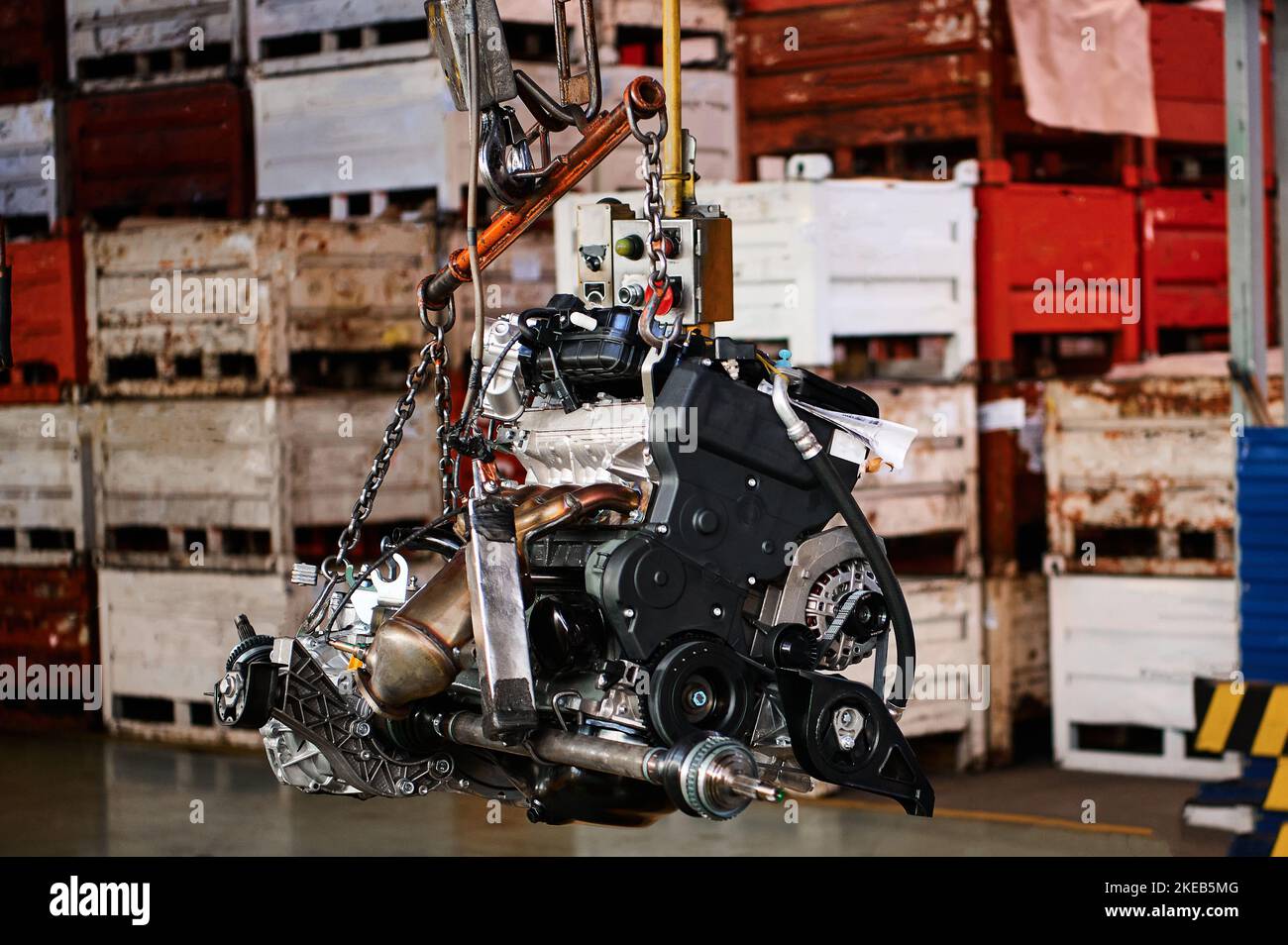 Powerful car motor hangs on chains in assembling workshop Stock Photo ...
