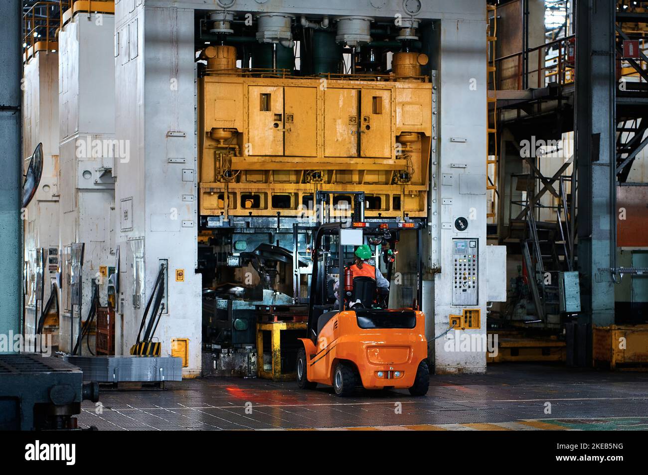 Giant stamping press. Sheet metal stamping. Electric forklift brings a ...