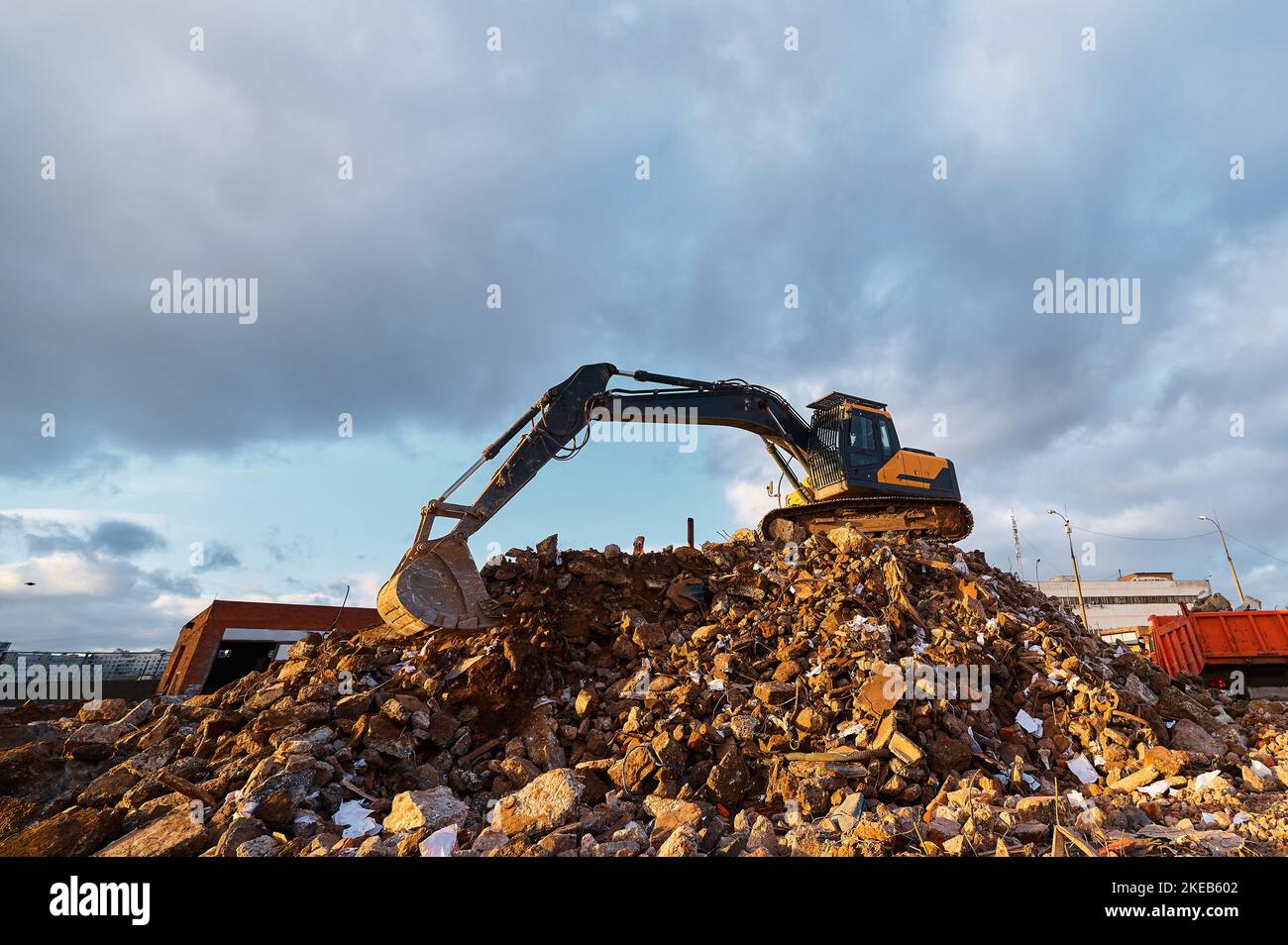 Building excavator with bucket work on concrete waste Stock Photo - Alamy