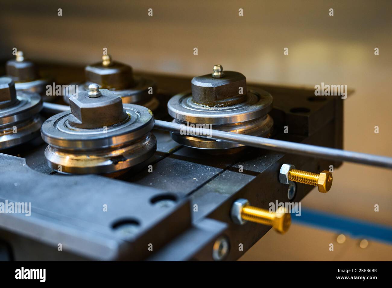 Metal cable pulled out through rollers line on machine tool Stock Photo ...