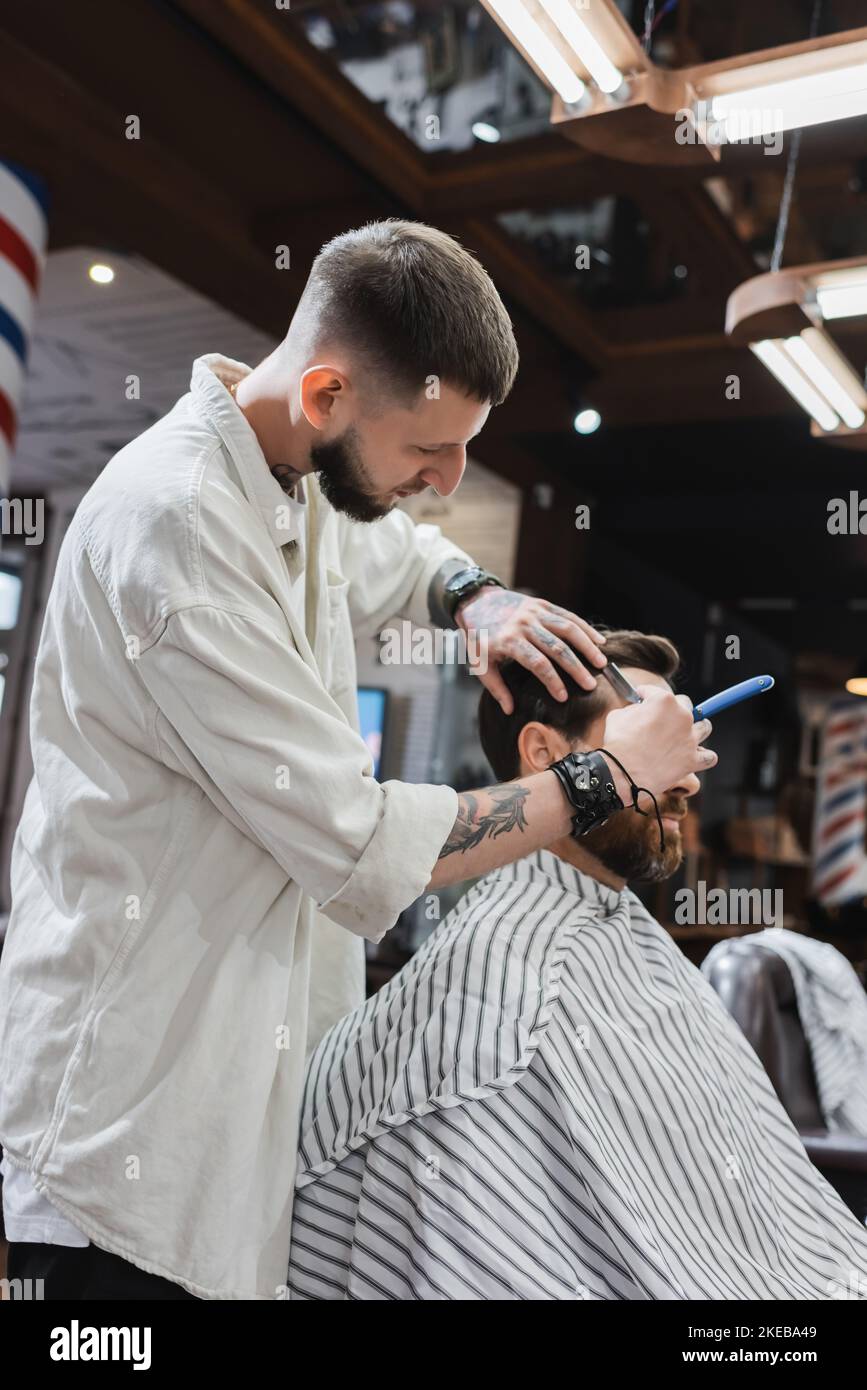 professional barber shaving forehead of man with straight razor,stock ...