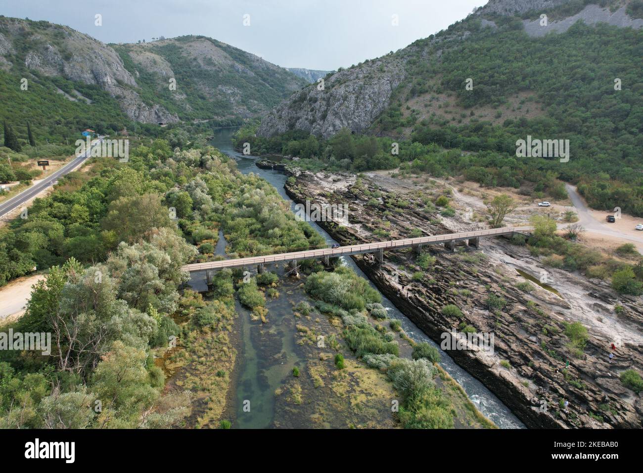 A high angle of a bridge in the middle of valley with trees and grasses ...