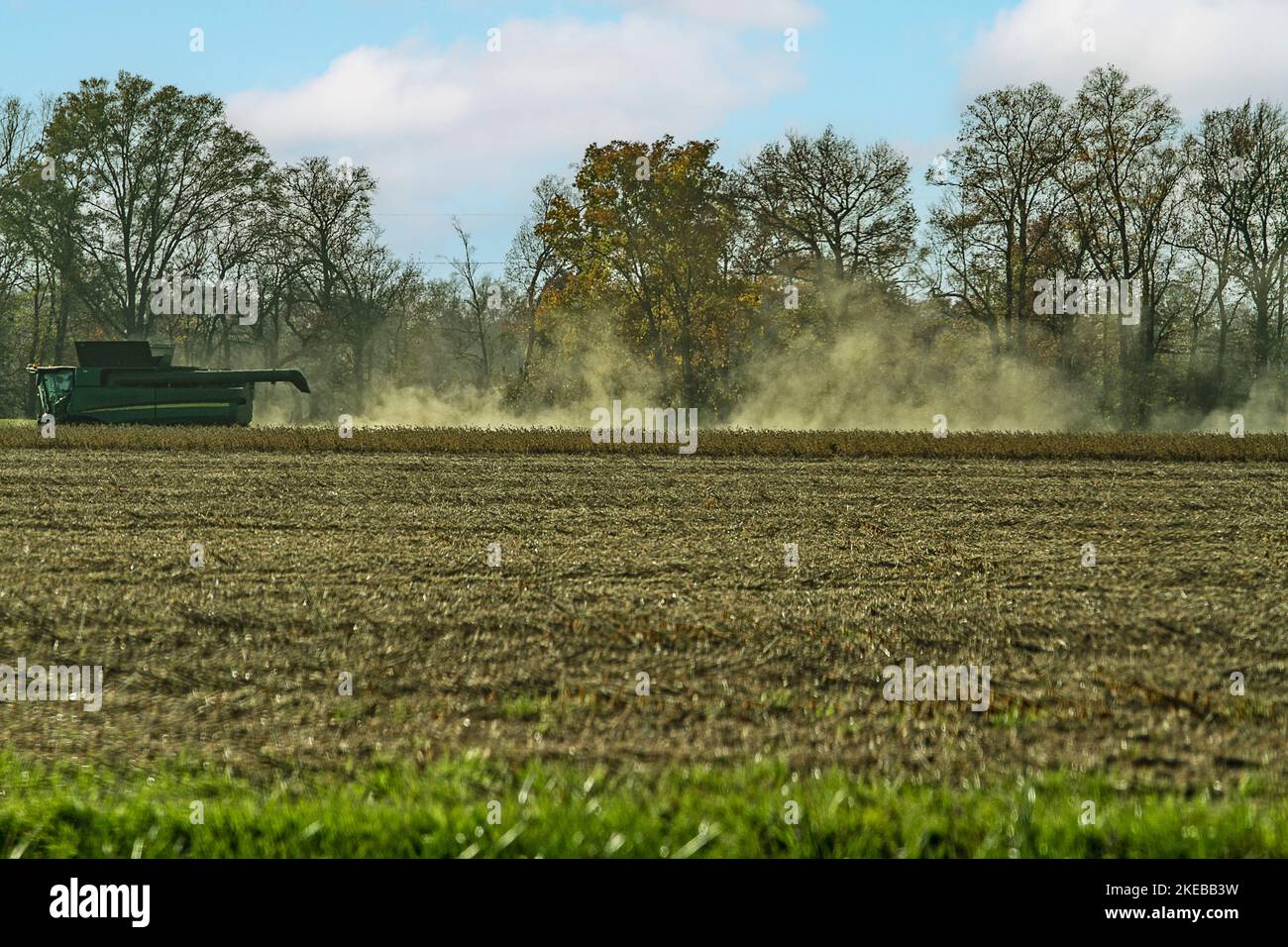 Farmer plowing his fields with leaving a trail of dust Stock Photo - Alamy