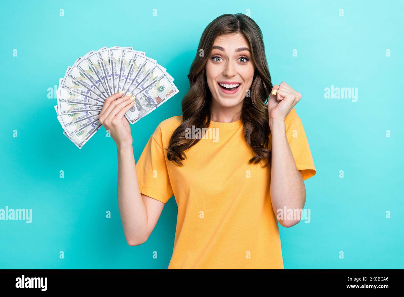 Photo of young adorable pretty cute funny woman hold cash dollars fist ...