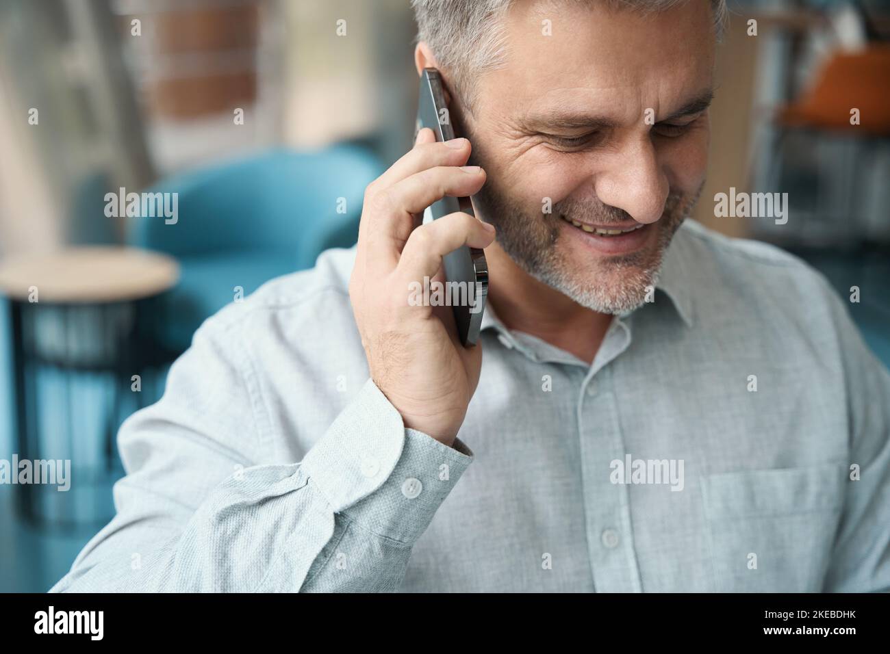Middle-aged man in light shirt is talking on mobile phone Stock Photo ...
