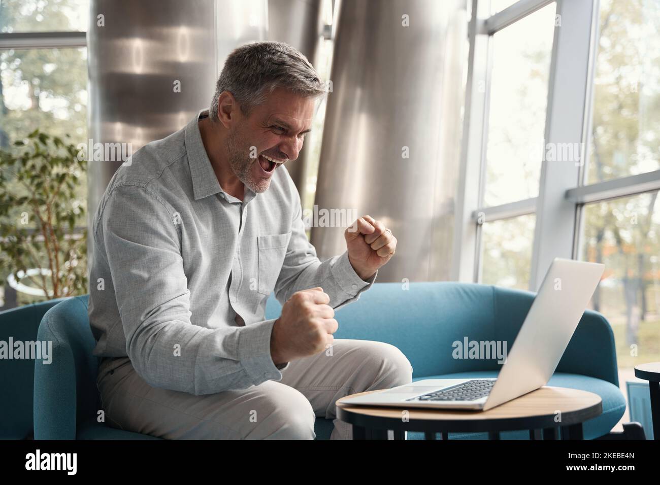 Man in front of laptop in coworking emotionally reacts to business ...