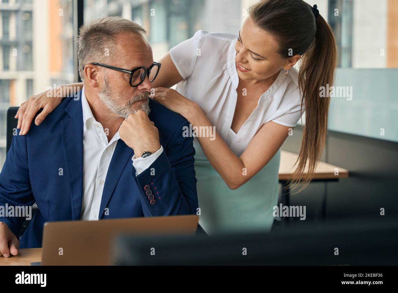 Young woman flirting with mature boss in office Stock Photo - Alamy