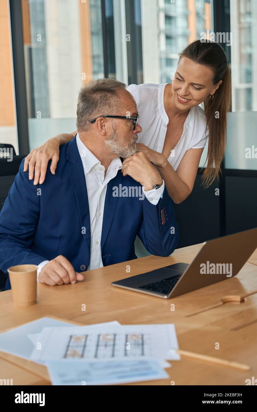 Young woman hugging mature boss during working day Stock Photo - Alamy