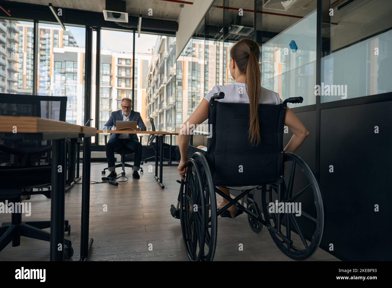 Woman in wheelchair applying for job in office Stock Photo - Alamy