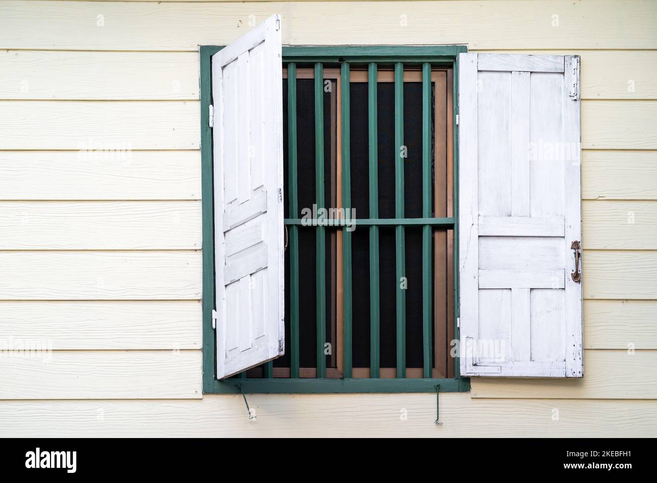 White folding wooden window with green steel grill protection on ...