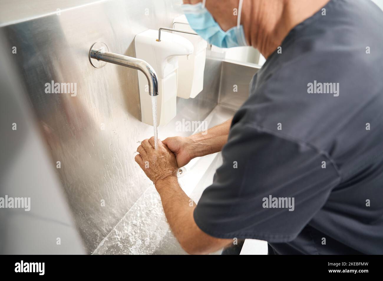 Medical worker cleaning hands before examining patient Stock Photo - Alamy