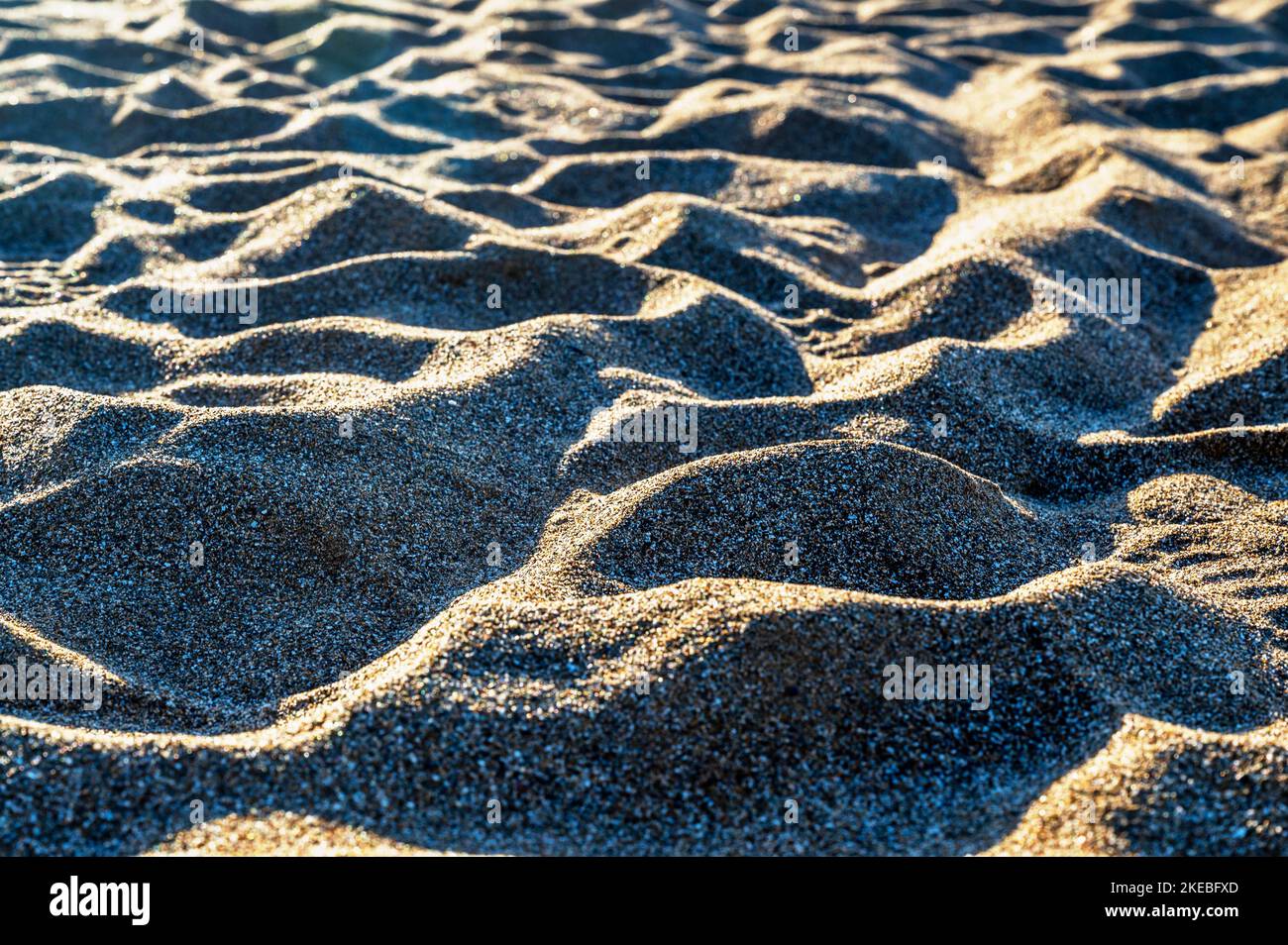 Undulating shapes of sand in sunset light on beach Stock Photo - Alamy