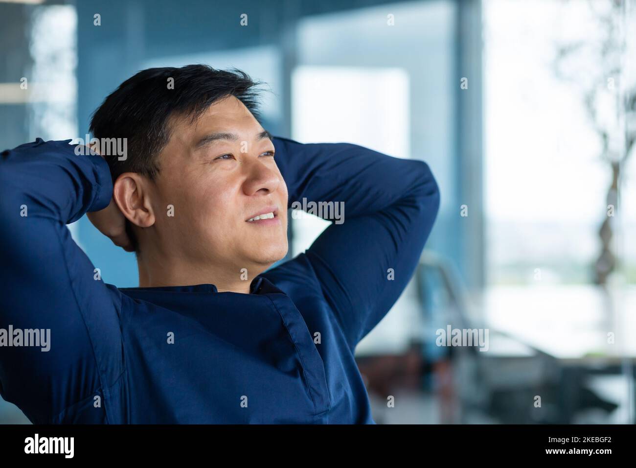 Asian man at home by the window resting and daydreaming, man in a shirt ...