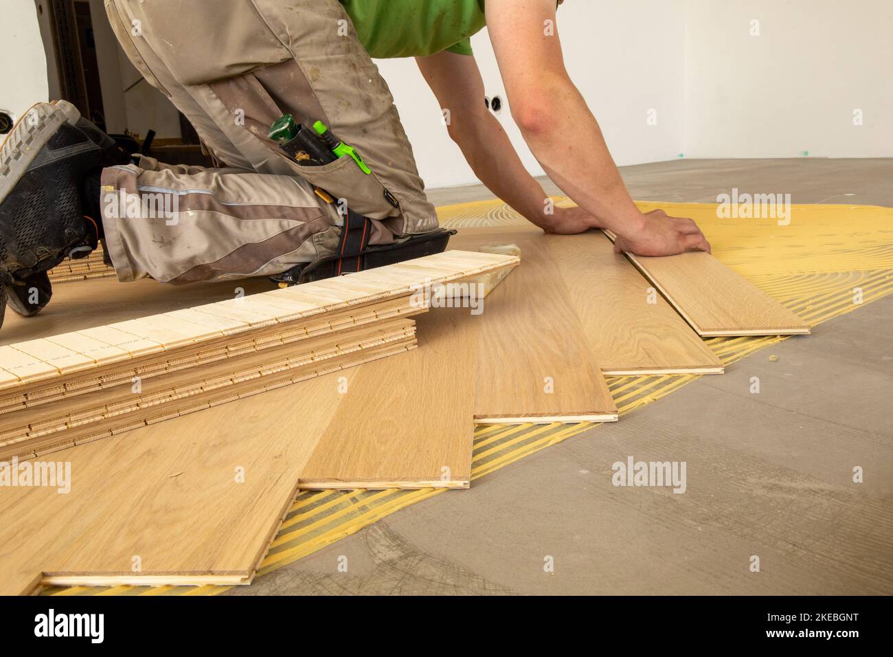 Craftsman laying herringbone parquet flooring professionally Stock Photo - Alamy