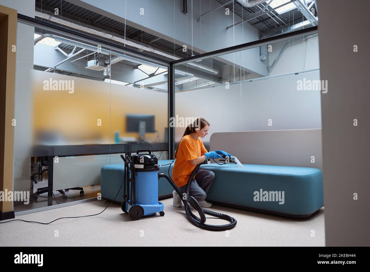 Dedicated cleaning company employee meticulously vacuuming the couch ...