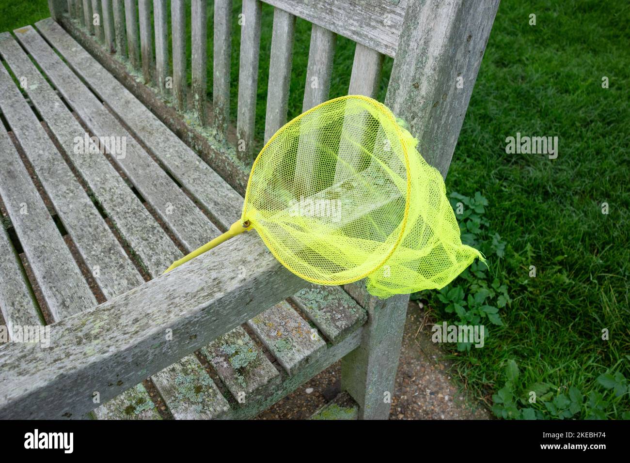 Children's Yellow fishing net on a long pole left behind on a park ...