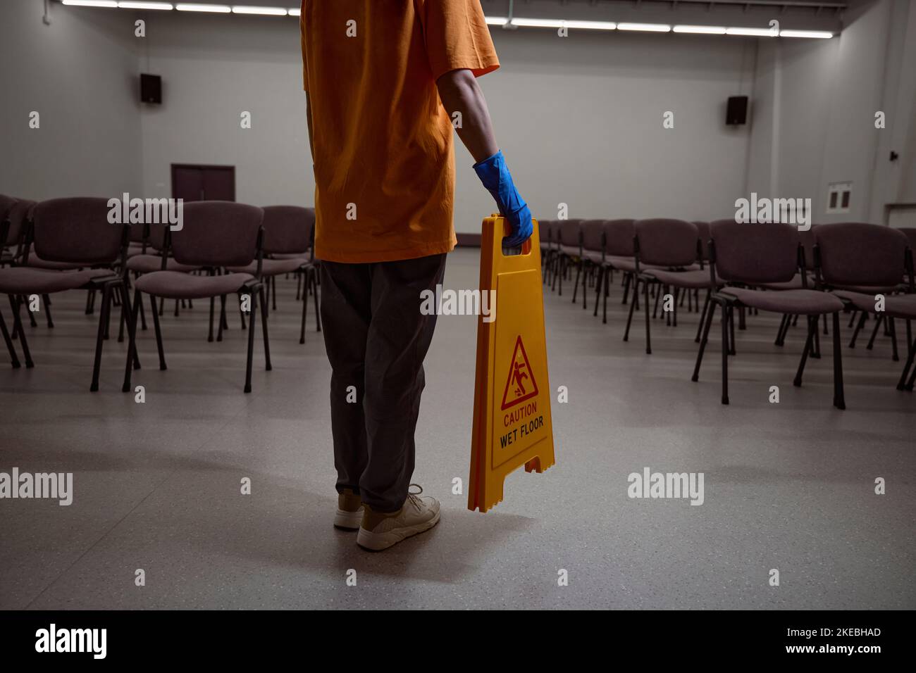 Mindful janitor putting a yellow warning sign on the wet floor Stock ...