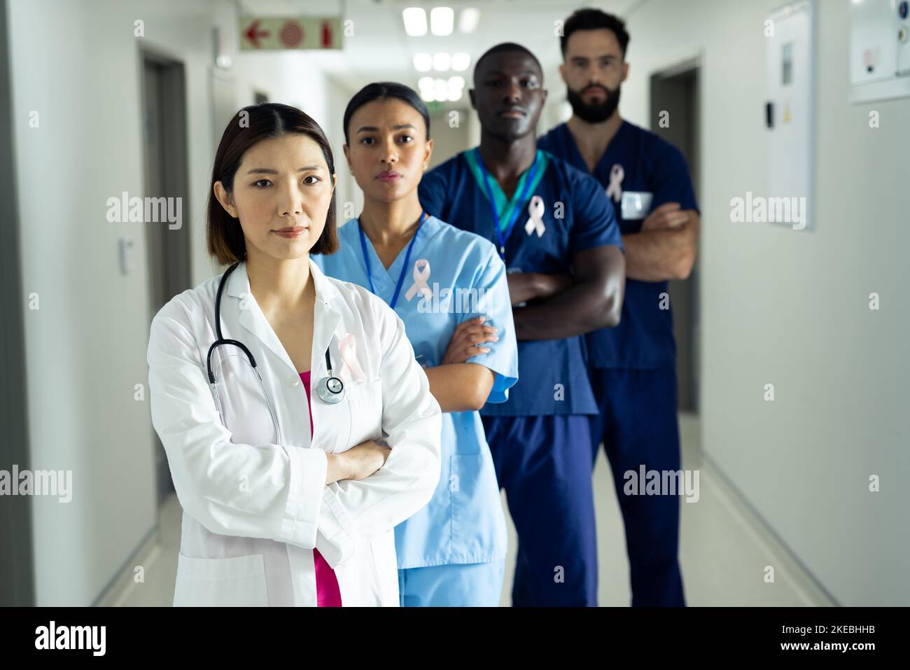 Portrait of diverse group of healthcare workers wearing cancer ribbons ...