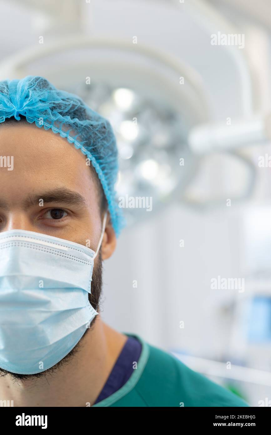 Vertical half portrait of caucasian male surgeon in surgical mask and ...