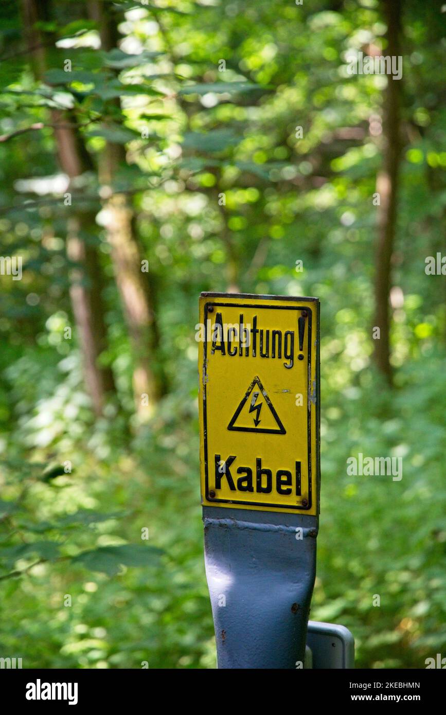 A vertical shot of a German yellow sing - danger cable Stock Photo - Alamy
