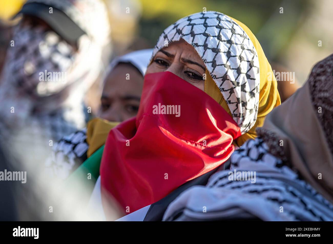 A Palestinian woman wears the Palestinian keffiyeh on her head during a ...