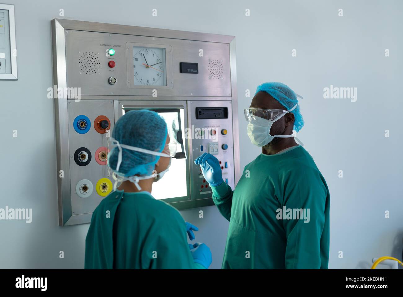 Two diverse surgeons discussing x-ray on lightbox in operating theatre ...