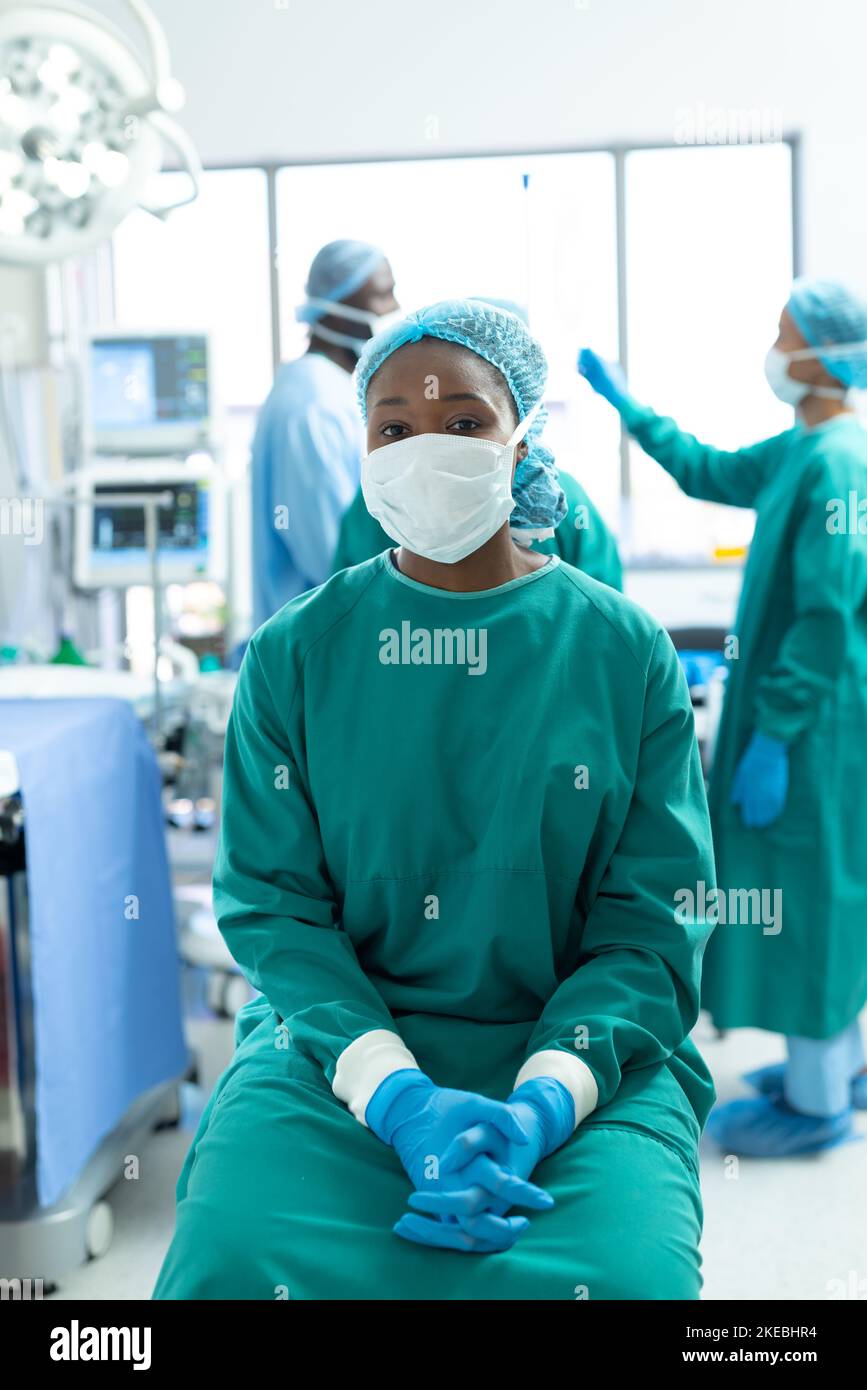 Vertical portrait of african american female surgeon in operating ...